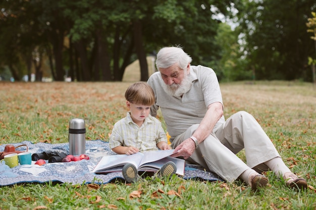 Abuelo enseñando a nieto a leer | Foto Gratis Abuelo enseñando a nieto a leer | Foto Gratis