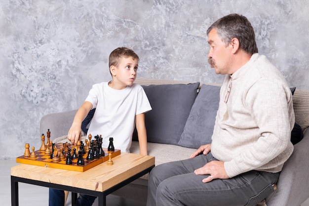 Abuelo jugando al ajedrez con su nieto interior. el niño y su abuelo ... Abuelo jugando al ajedrez con su nieto interior. el niño y su abuelo ...