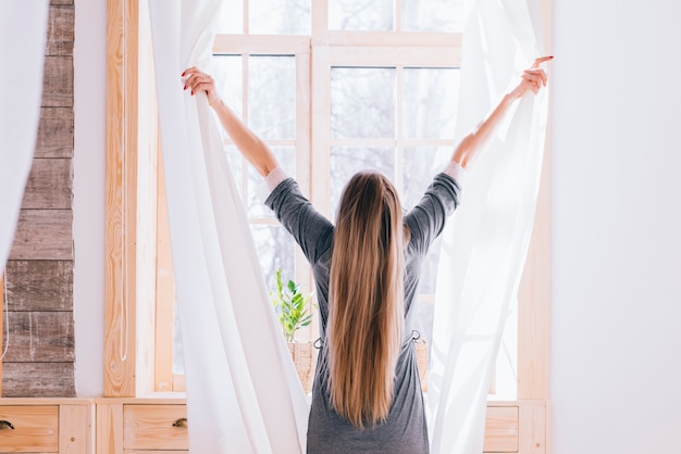 Chica Abriendo Cortinas Foto Gratis