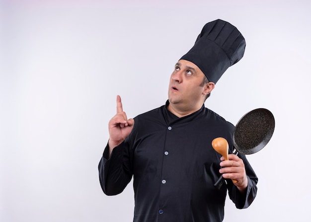 Cocinero cocinero masculino vistiendo uniforme negro y sombrero de ... Cocinero cocinero masculino vistiendo uniforme negro y sombrero de ...