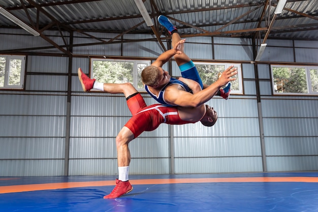 Dos Hombres Fuertes En Mallas De Lucha Azul Y Rojo Foto Premium