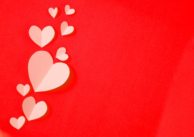 Elementos De Papel En Forma De Corazón Volando Sobre Papel Rojo Foto