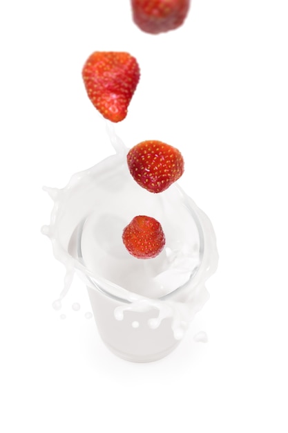 Fresa cayendo en un vaso de leche con salpicaduras | Foto Premium Fresa cayendo en un vaso de leche con salpicaduras | Foto Premium
