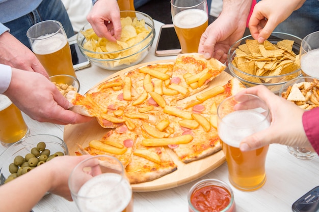 Un Grupo De Amigos Está Bebiendo Cerveza Comiendo Pizza Hablando Y