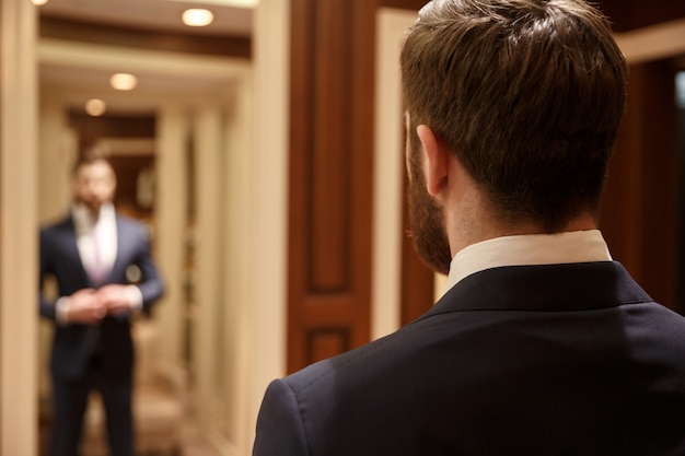 Hombre mirando en el espejo con traje | Foto Gratis Hombre mirando en el espejo con traje | Foto Gratis