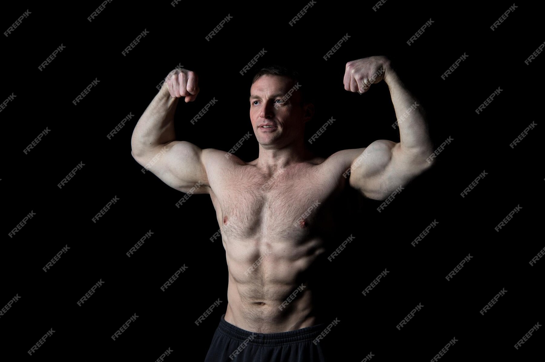 Hombre O Deportista Flexionando Los Brazos Con Los Puños Culturista