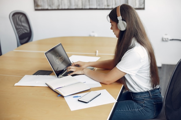 Joven estudiante sentado en la mesa y usar la computadora portátil ... Joven estudiante sentado en la mesa y usar la computadora portátil ...