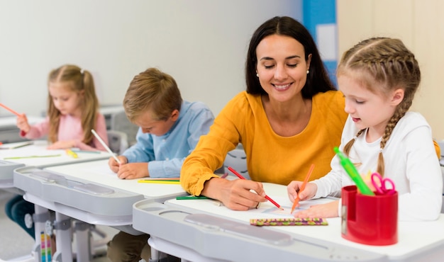 Maestra Feliz Ayudando A Sus Alumnos Foto Gratis