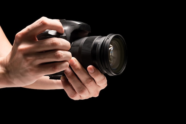 Mano masculina que sostiene una cámara digital en un fondo negro ... Mano masculina que sostiene una cámara digital en un fondo negro ...