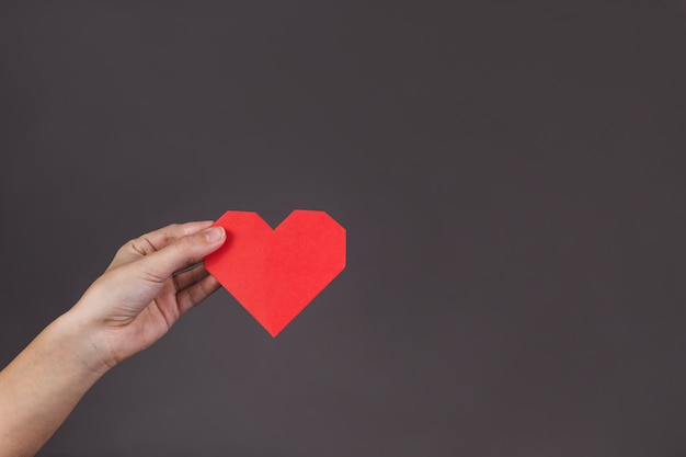 Mano sujetando un corazón de papel | Foto Gratis Mano sujetando un corazón de papel | Foto Gratis