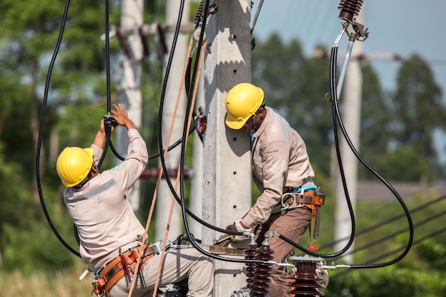 Mono de electricista trabajando en altura y peligroso | Foto Premium Mono de electricista trabajando en altura y peligroso | Foto Premium