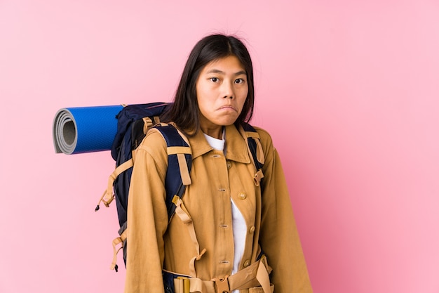 La mujer china joven del viajero aislada encoge de hombros y abre los ... La mujer china joven del viajero aislada encoge de hombros y abre los ...