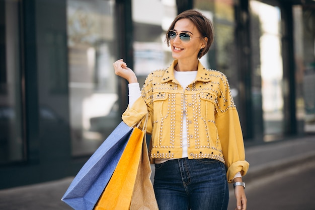 Mujer joven con bolsas de compras en la ciudad | Foto Gratis Mujer joven con bolsas de compras en la ciudad | Foto Gratis