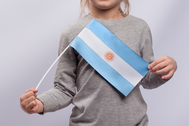 Niño sostiene la bandera de argentina en sus manos. de cerca | Foto Premium Niño sostiene la bandera de argentina en sus manos. de cerca | Foto Premium