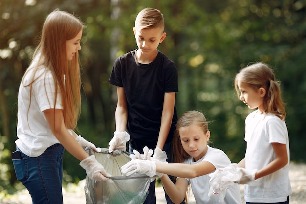 Los niños recogen basura en bolsas de basura en el parque | Foto Gratis Los niños recogen basura en bolsas de basura en el parque | Foto Gratis