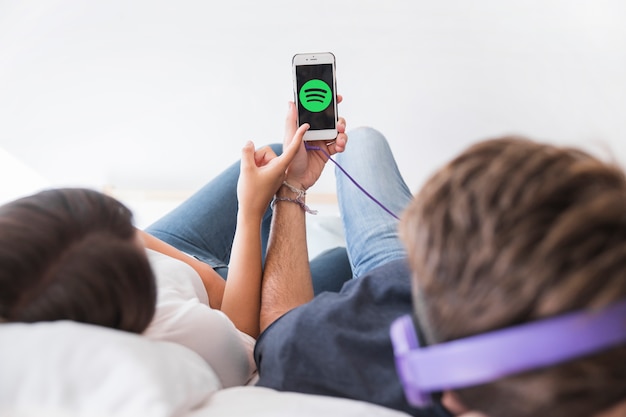 Pareja joven escuchando música con la app de spotify | Foto Gratis Pareja joven escuchando música con la app de spotify | Foto Gratis
