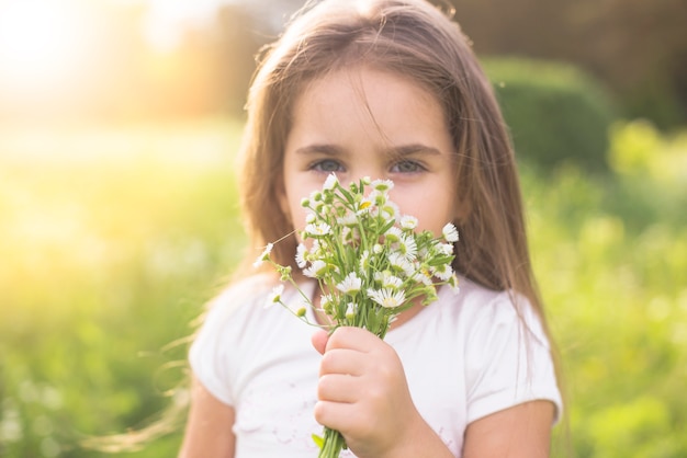 Primer plano de una niña que huele a flores blancas | Foto Gratis Primer plano de una niña que huele a flores blancas | Foto Gratis