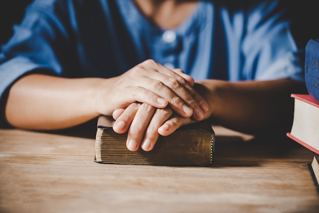 Spiritualità e religione, mani giunte in preghiera su una sacra bibbia ... Spiritualità e religione, mani giunte in preghiera su una sacra bibbia ...