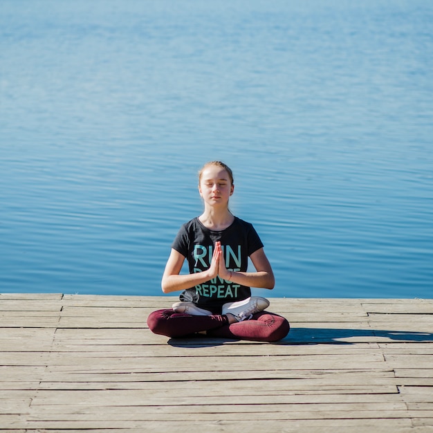 Adolescente meditando perto da água | Foto Grátis Adolescente meditando perto da água | Foto Grátis