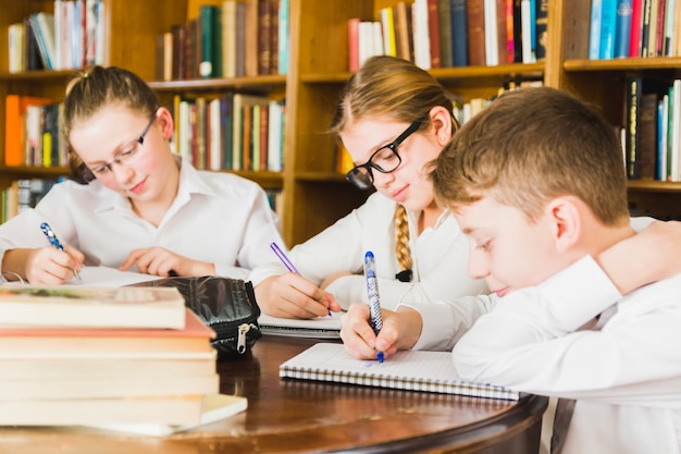Bonitos crianças estudando na biblioteca da escola | Foto Grátis Bonitos crianças estudando na biblioteca da escola | Foto Grátis