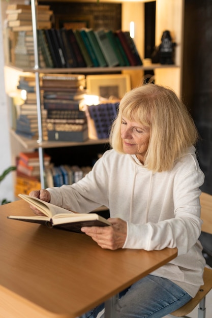 Mulher idosa lendo um livro em casa | Foto Grátis Mulher idosa lendo um livro em casa | Foto Grátis