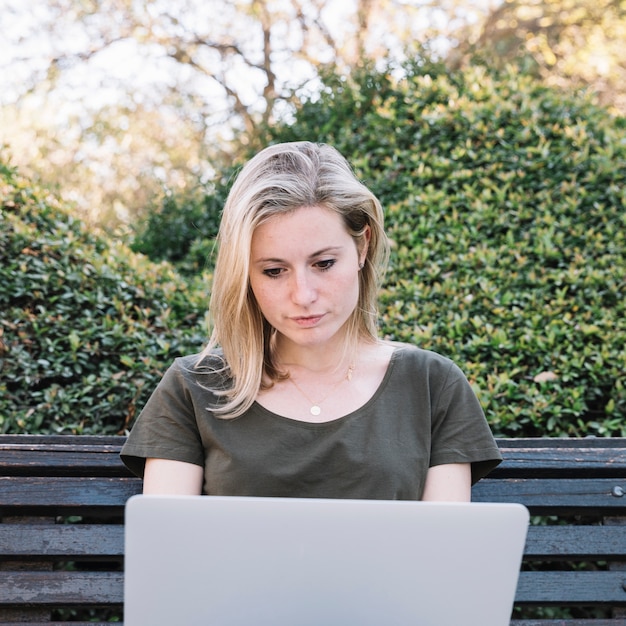 Mulher jovem, usando computador portátil, ligado, banco | Foto Grátis Mulher jovem, usando computador portátil, ligado, banco | Foto Grátis