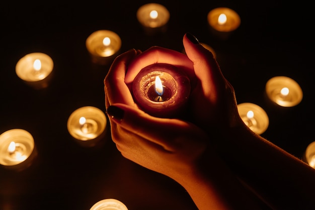 Queima de velas. vela em mãos femininas. muitas velas acesas à noite ... Queima de velas. vela em mãos femininas. muitas velas acesas à noite ...