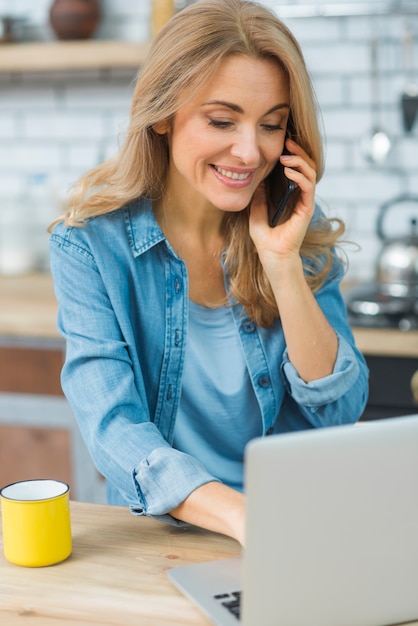 Sorrindo, mulher jovem, usando computador portátil, falando telefone ... Sorrindo, mulher jovem, usando computador portátil, falando telefone ...