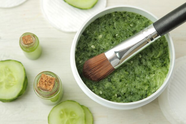 Gesichtsmaske mit gurke. kosmetik mit gurkenextrakt auf einem weißen ... Gesichtsmaske mit gurke. kosmetik mit gurkenextrakt auf einem weißen ...