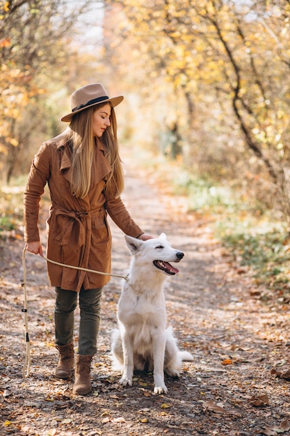 Junge frau im park mit ihrem weißen hund | Kostenlose Foto Junge frau im park mit ihrem weißen hund | Kostenlose Foto