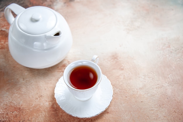 Seitliche nahaufnahme eine tasse tee weiße teekanne eine tasse tee ... Seitliche nahaufnahme eine tasse tee weiße teekanne eine tasse tee ...