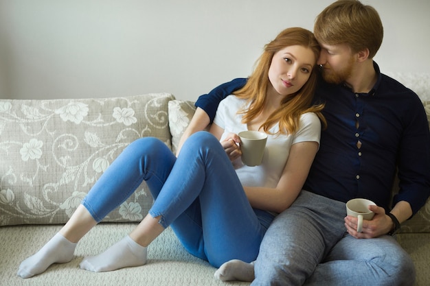 Premium Photo Beautiful Couple Man And Woman Sitting On The Sofa At Home