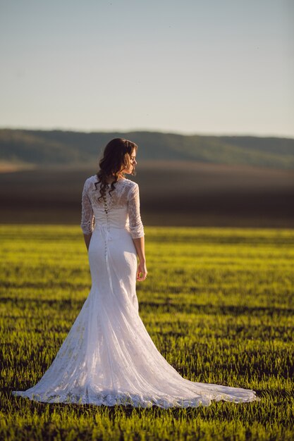 Premium Photo Bride In A Lace Wedding Dress Standing On A Field