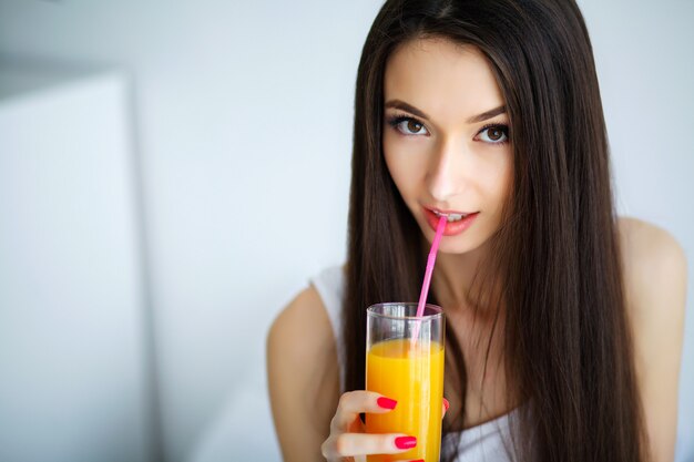 Premium Photo Casual Smiling Woman Holding A Glass Of Orange Juice