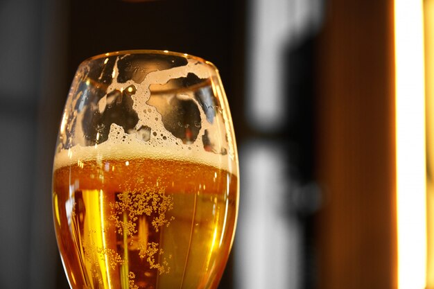 Premium Photo Close Up On A Pint Glass Of Amber Pale Ale Beer Casting A Shadow On A Wood Table