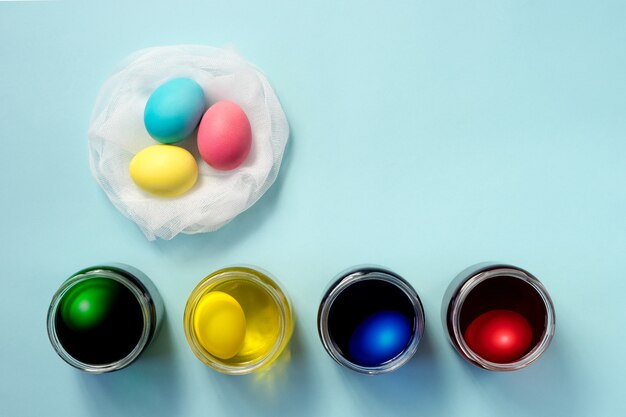 Premium Photo Colored Easter Eggs And Egg Dyeing Set On Blue Background