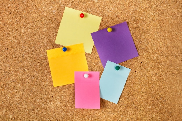 Premium Photo | Colored sticky notes hanging on a cork board Premium Photo | Colored sticky notes hanging on a cork board
