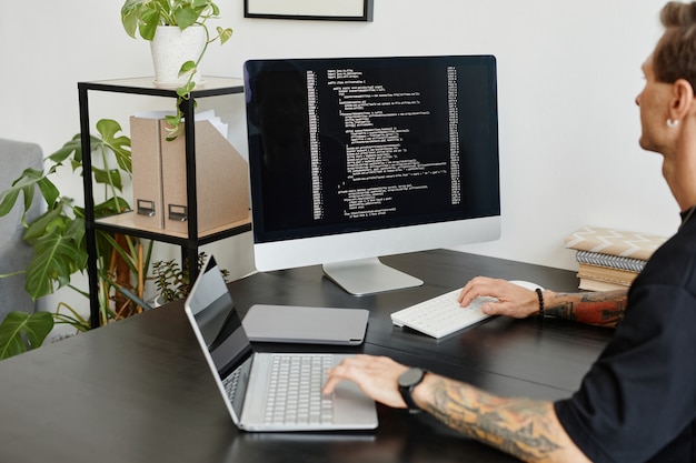 Premium Photo | Computer programmer sitting at the table in front of ...