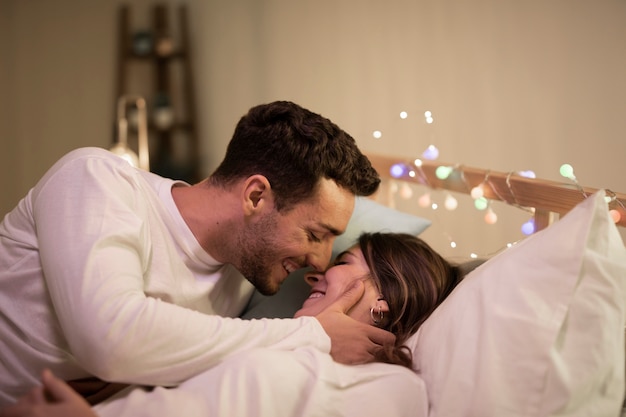 Free Photo Couple Cuddling And Kissing In Bed