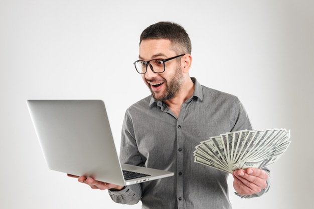 Premium Photo | Excited businessman using laptop computer holding money. Premium Photo | Excited businessman using laptop computer holding money.