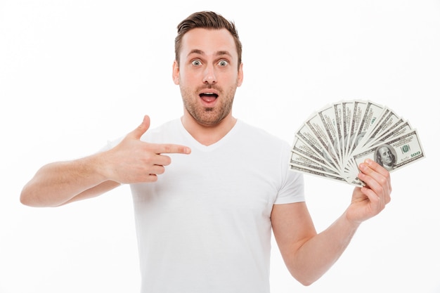 Free Photo | Excited young man pointing and holding money. Free Photo | Excited young man pointing and holding money.