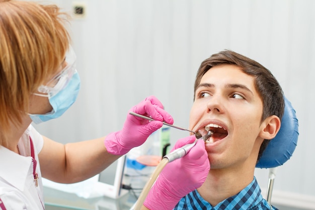 Premium Photo Female Dentist Is Treating A Patient Tooth In Dental