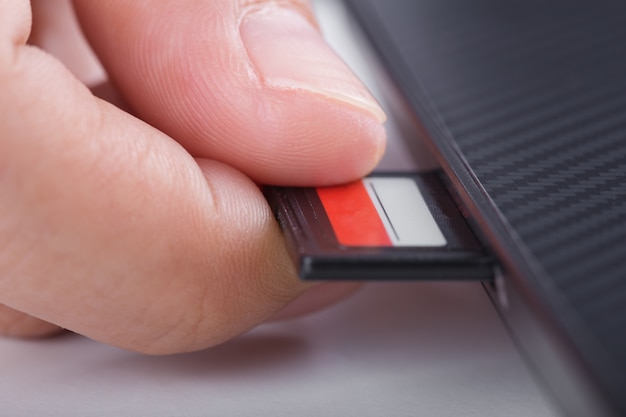 Premium Photo | Hand inserting sd card into laptop Premium Photo | Hand inserting sd card into laptop