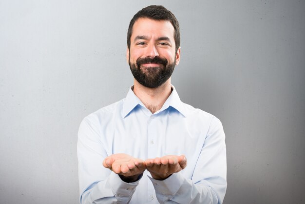 Premium Photo Handsome Man With Beard Holding Something On Textured
