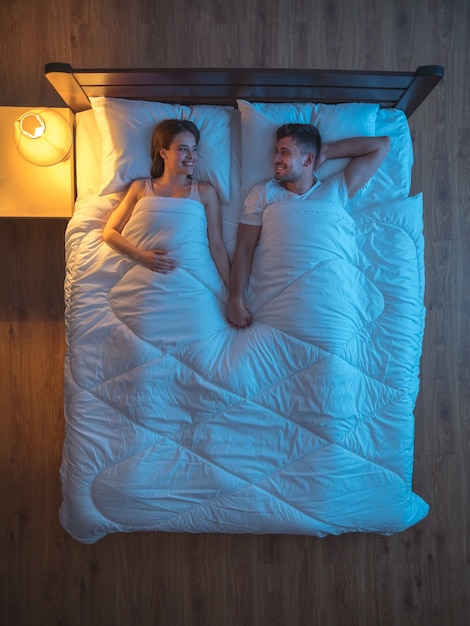 Premium Photo The Happy Couple Lie On The Bed Evening Night Time