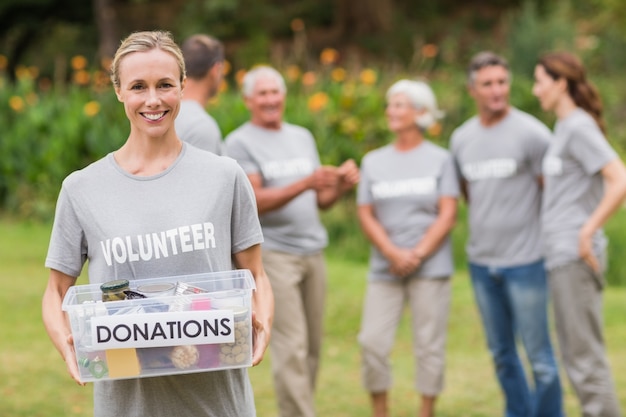 Premium Photo | Happy volunteer holding donation box Premium Photo | Happy volunteer holding donation box