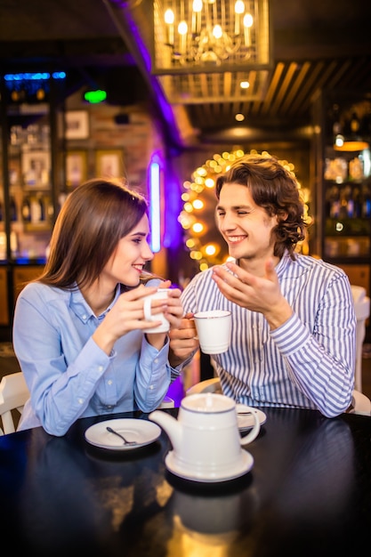 Premium Photo | Happy young man and woman drinking tea in cafe Premium Photo | Happy young man and woman drinking tea in cafe