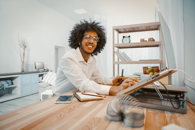 Premium Photo | Happy young man working with laptop at home workplace Premium Photo | Happy young man working with laptop at home workplace