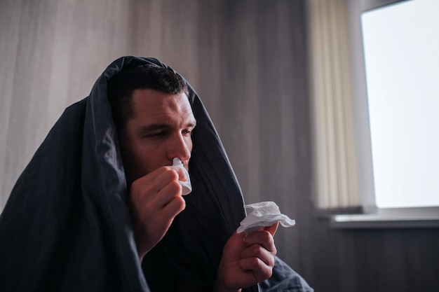 Premium Photo He Covered Himself With A Blanket And Holds A Napkin The Man Got Sick Lies In