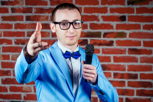 Premium Photo A Man Actor Comedian In Glasses A Stylish And Tie Suit Holds A Microphone